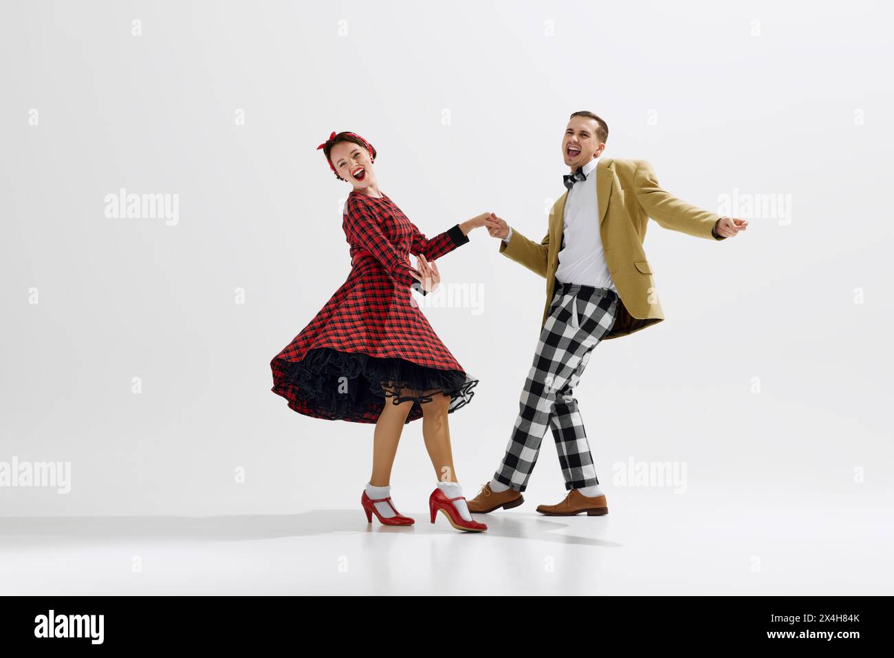 Young man and woman, couple dressed in retro-inspired outfits joyfully ...