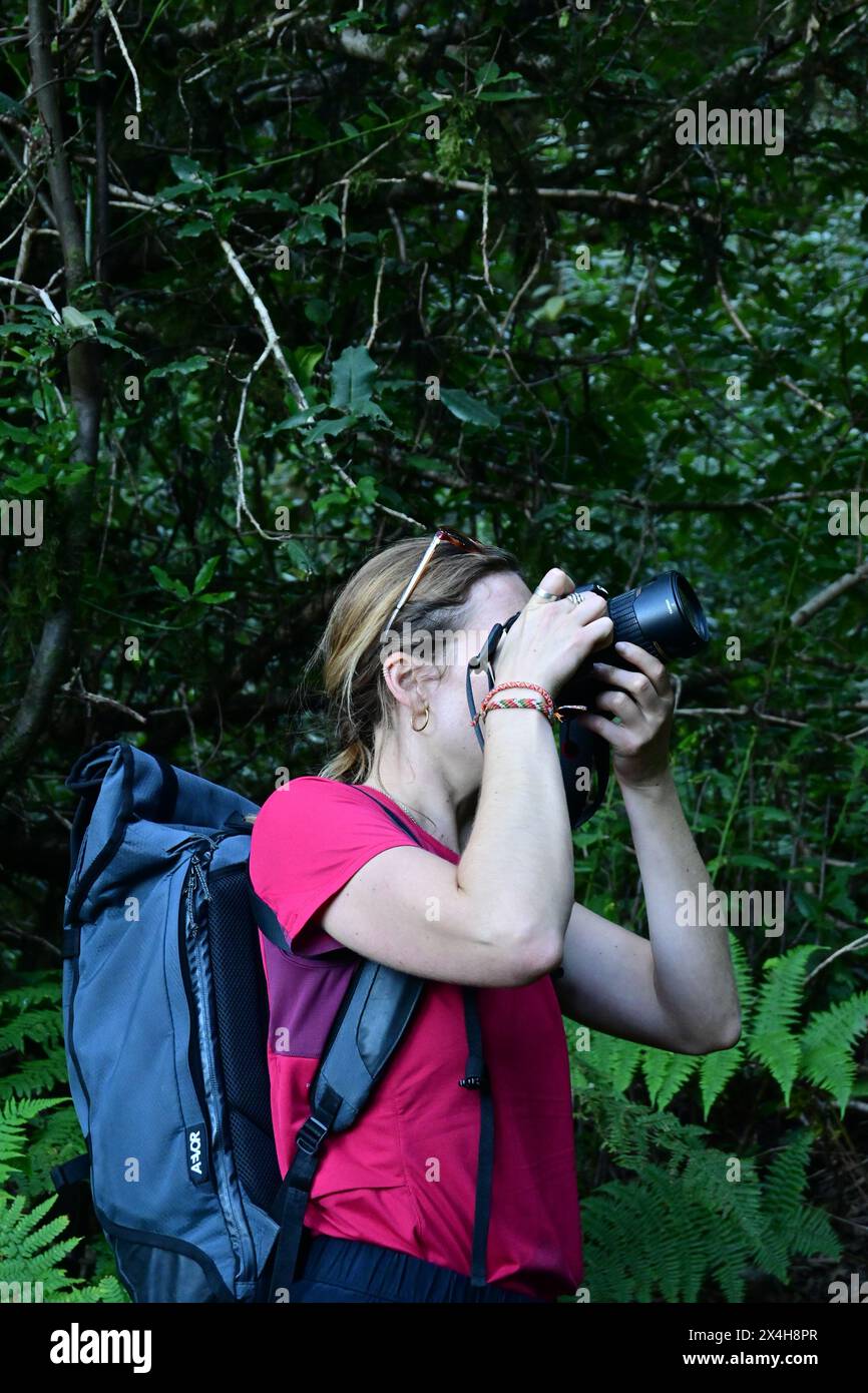 capturing nature's essence: young blonde woman with camera in hand ...