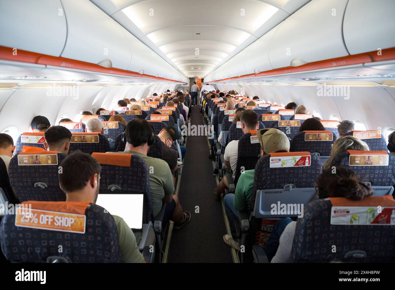 The cabin inside fuselage views down central aisle on a on an Easyjet Airbus plane / airplane ...