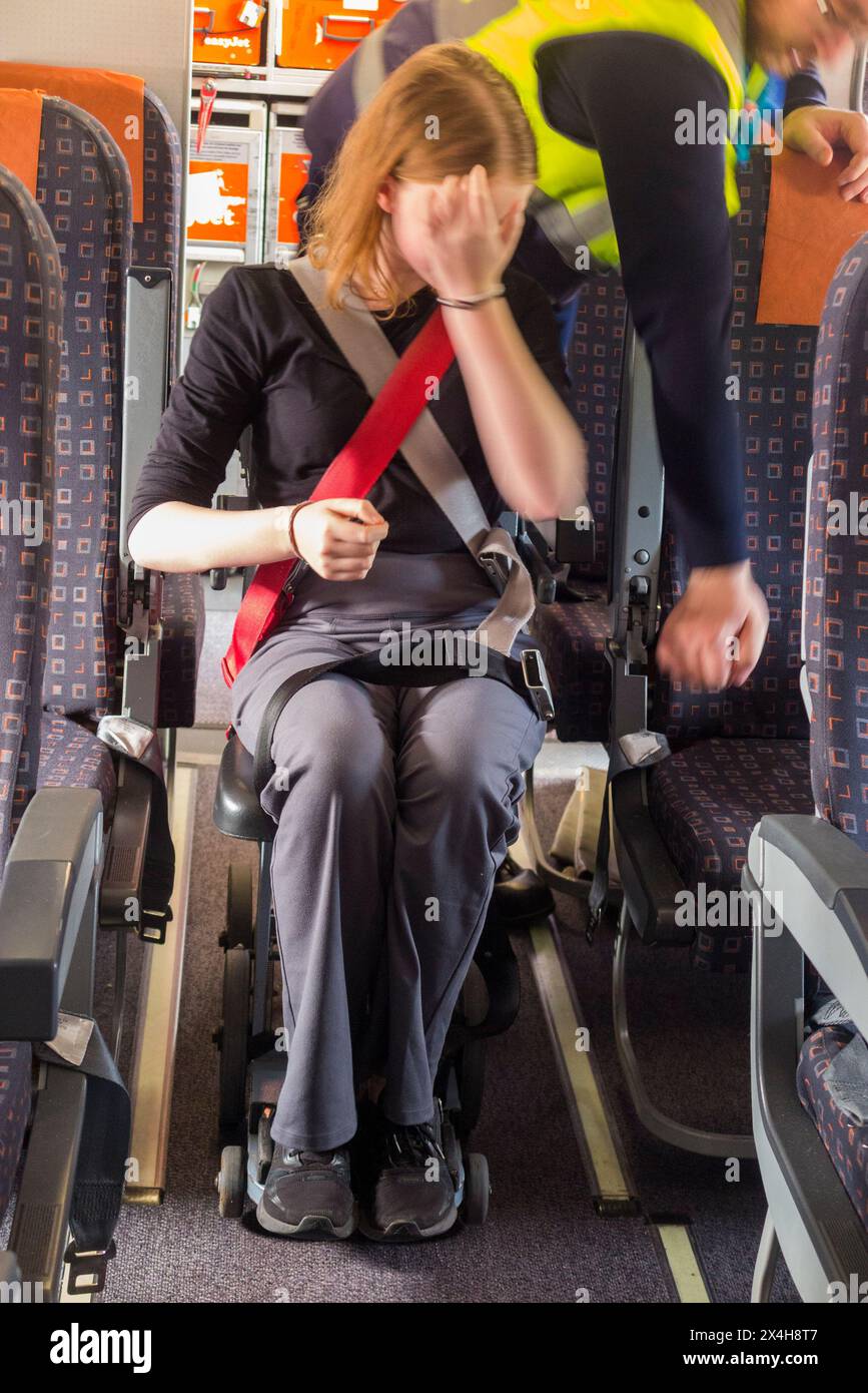Narrow slim wheelchair used to carry passenger along the cabin central ...