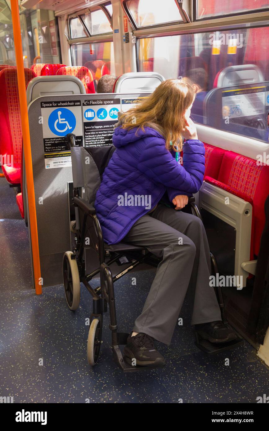 Teenager / teen / girl using a wheelchair to make a journey on a train ...