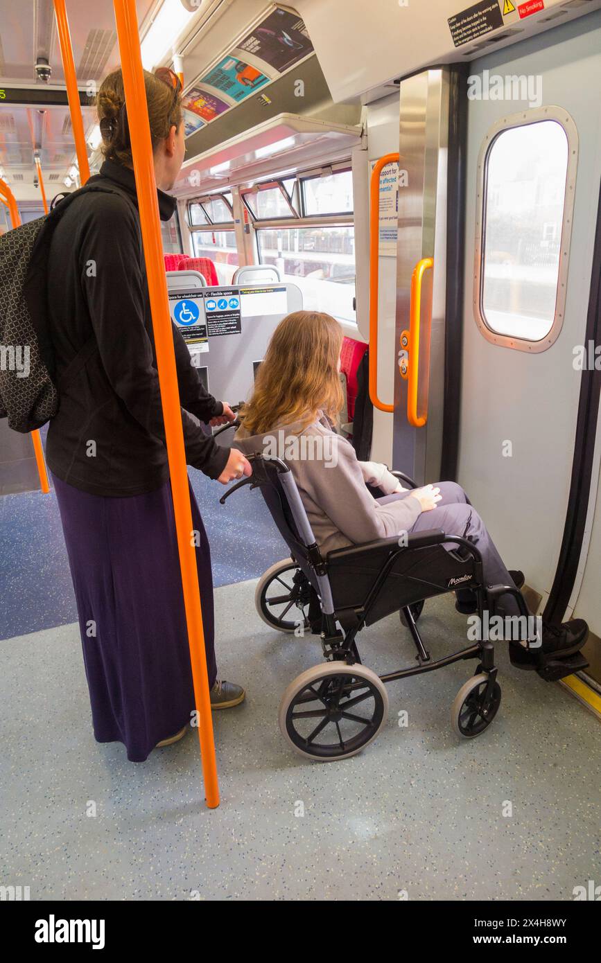 Mother and disabled daughter / girl using a wheelchair at access door ...