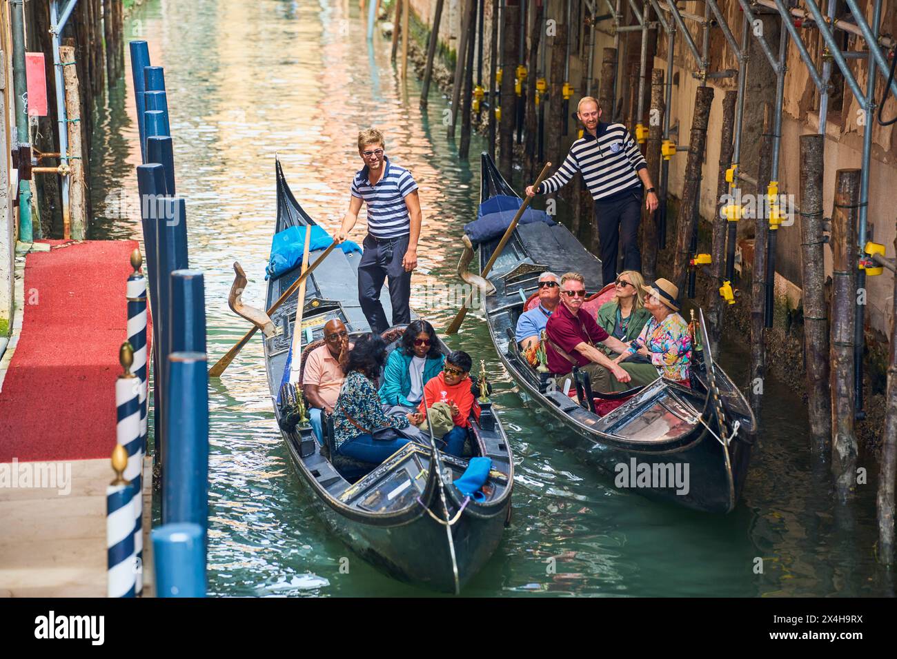Venice, Italy - May 3, 2024: Gondolier takes tourists on a gondola ride ...