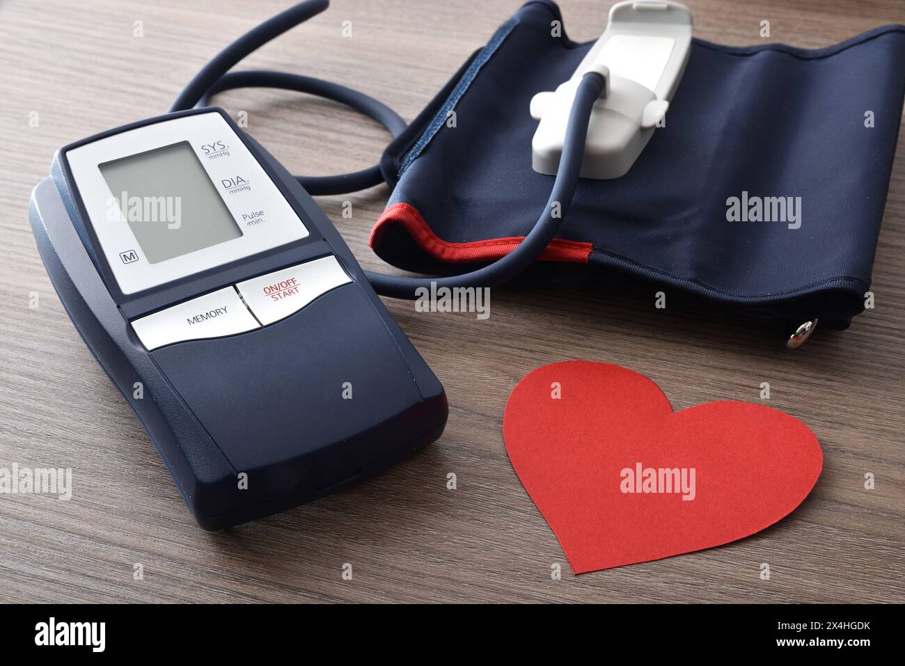 Blue digital blood pressure monitor for home on wooden table with ...