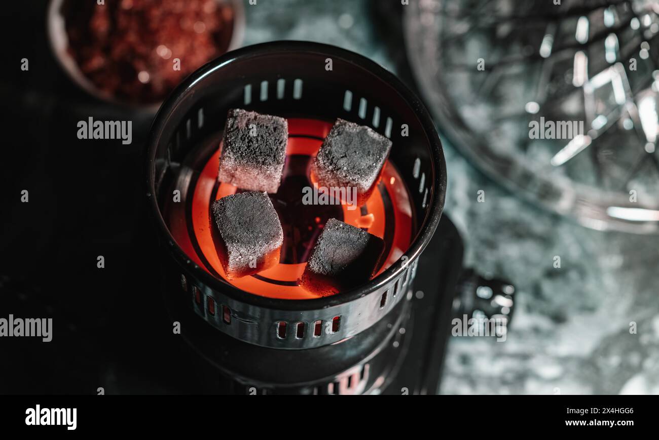 Red-hot charcoal briquettes heating in a Electric charcoal lighter for ...