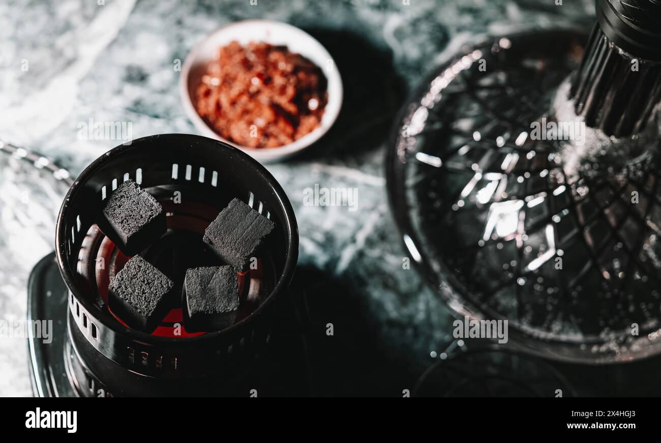 Glowing coals in an electric charcoal lighter for hookah, with a ...