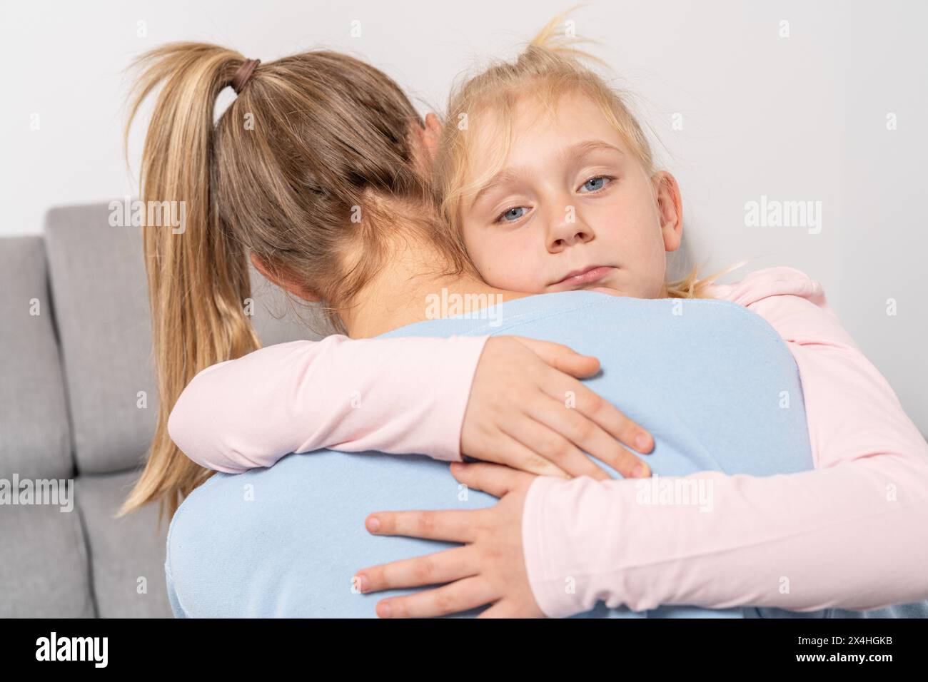 Loving and comforting embrace between two sisters at home. Showcasing ...