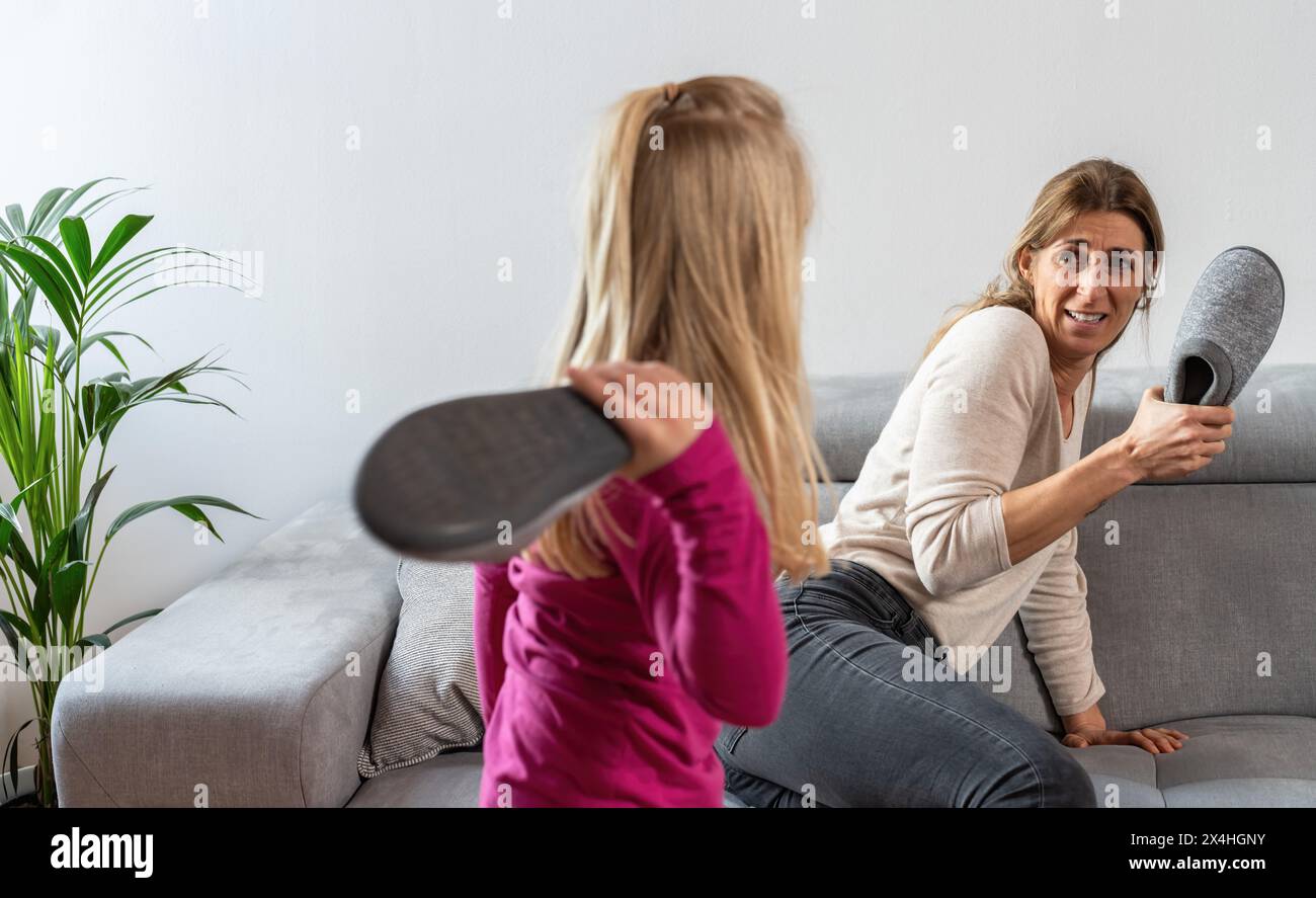 Mother and daughter each hold a slipper defensively in a tense moment ...