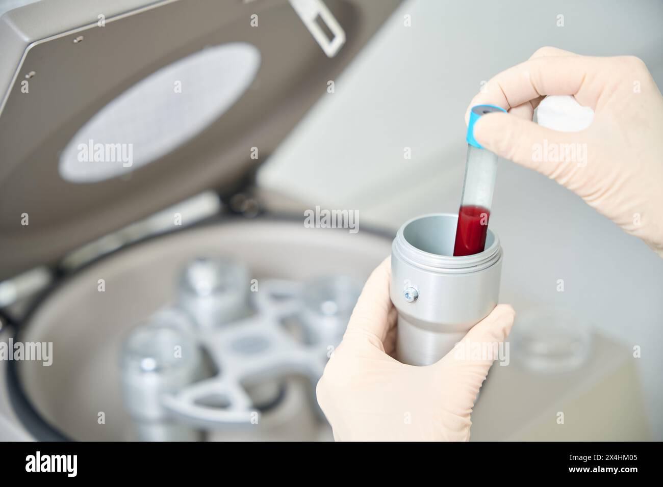 Nurse inserting vacutainer with blood sample into centrifuge Stock ...