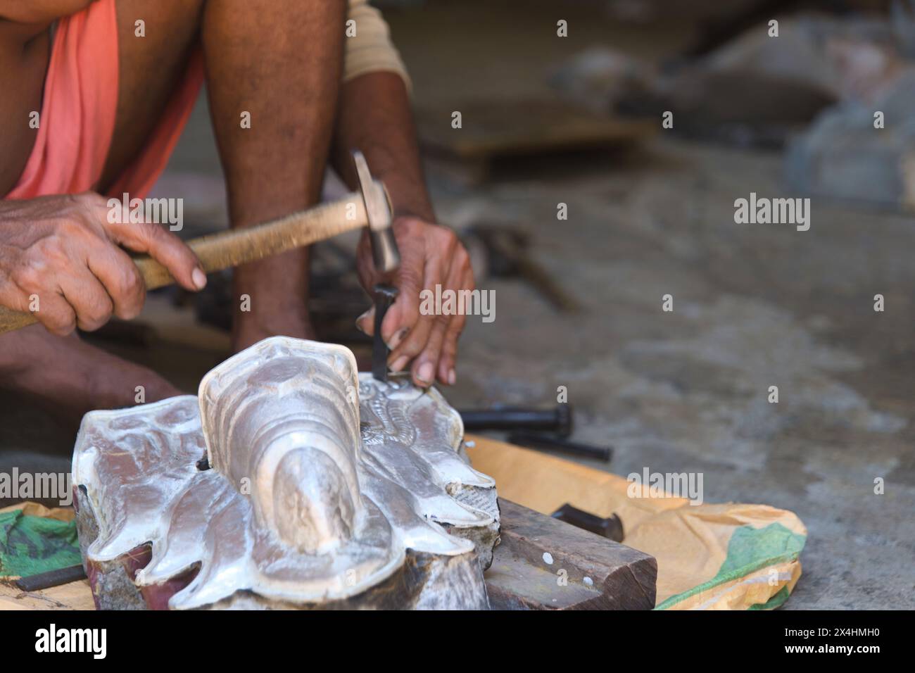 A skilled Indian craftsman shaping metal to create a religious idol in ...