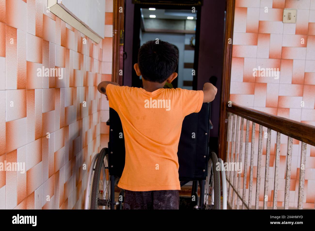 A young Asian boy with a determined expression stands beside his ...