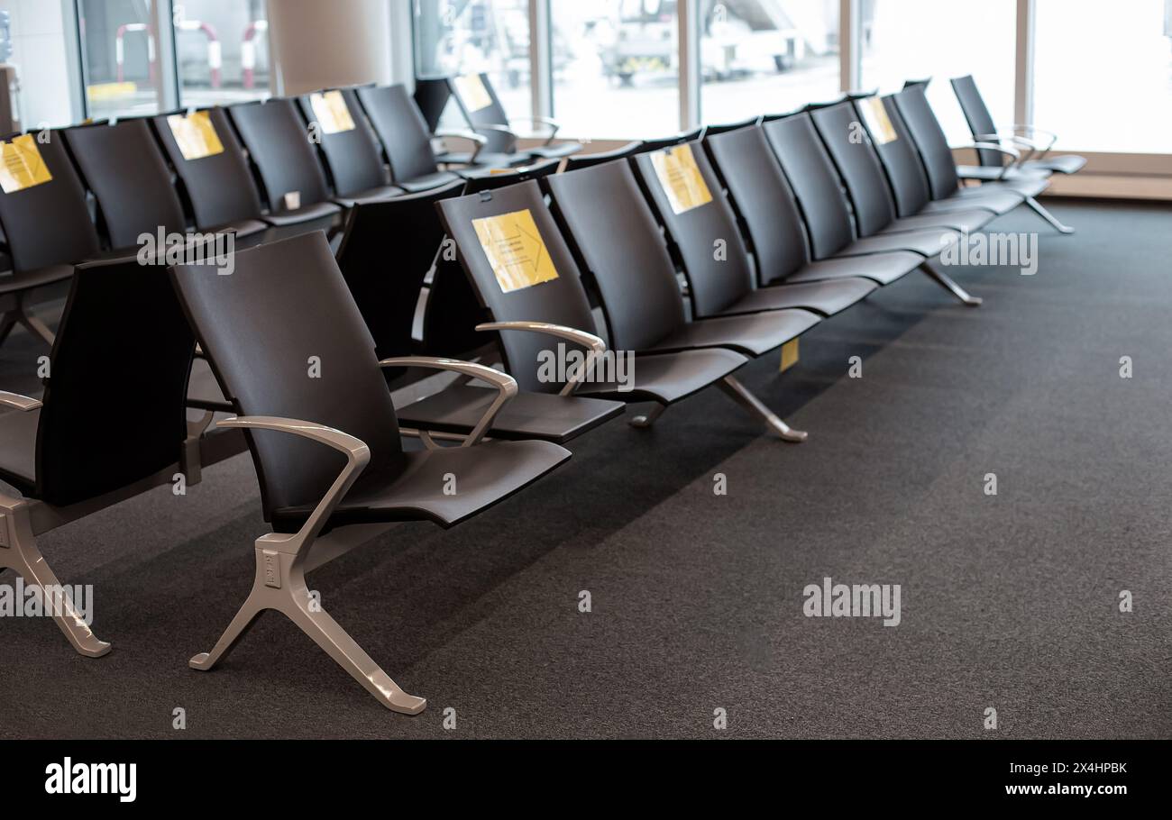 Empty airport waiting area with rows of seats and yellow signs ...