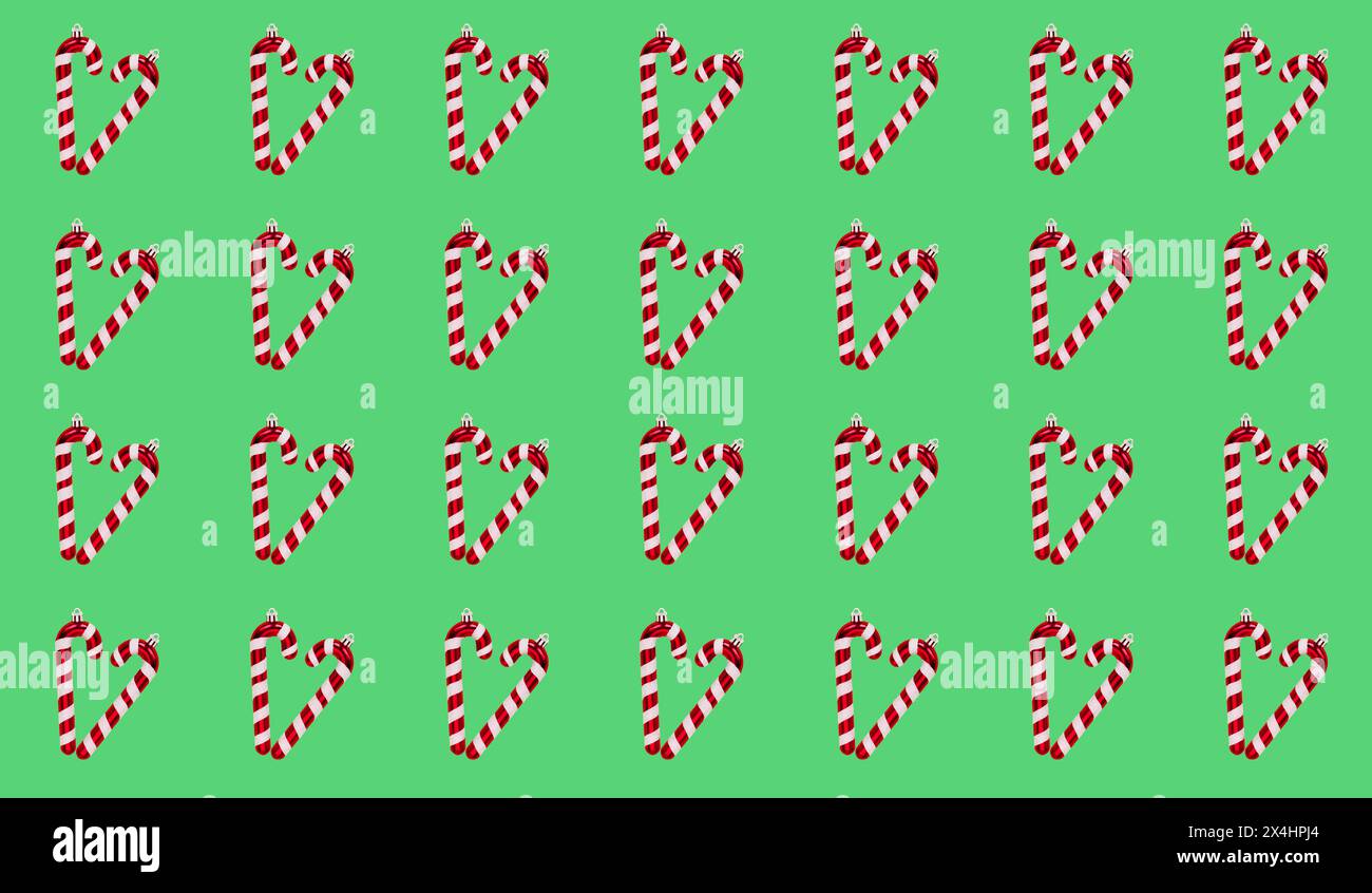 Repeated pattern of heart-shaped candy canes on a vibrant green ...