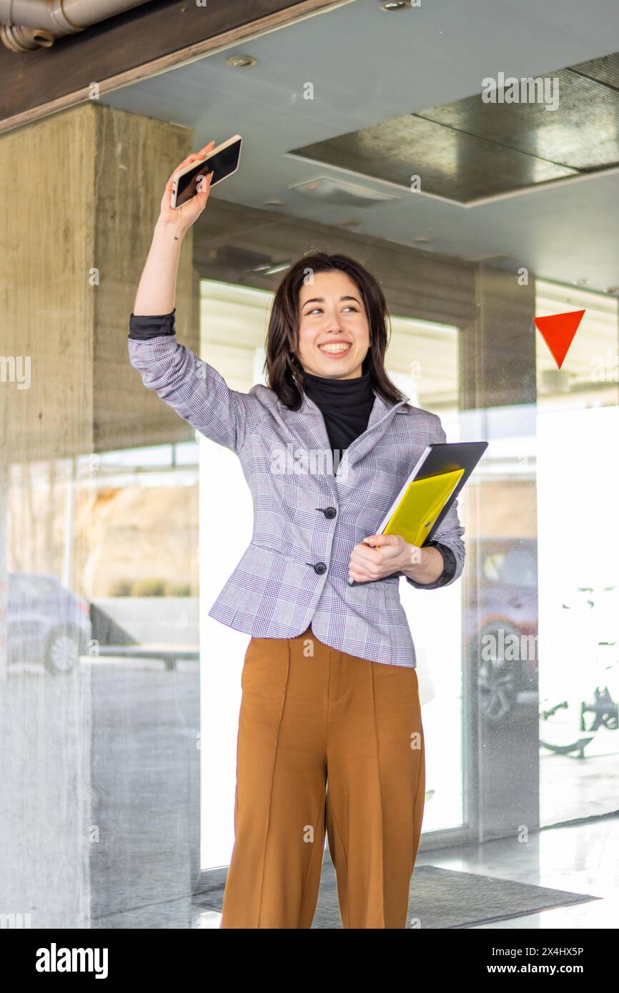 Woman in formal suit saying goodbye to a person outdoors. Portrait of ...