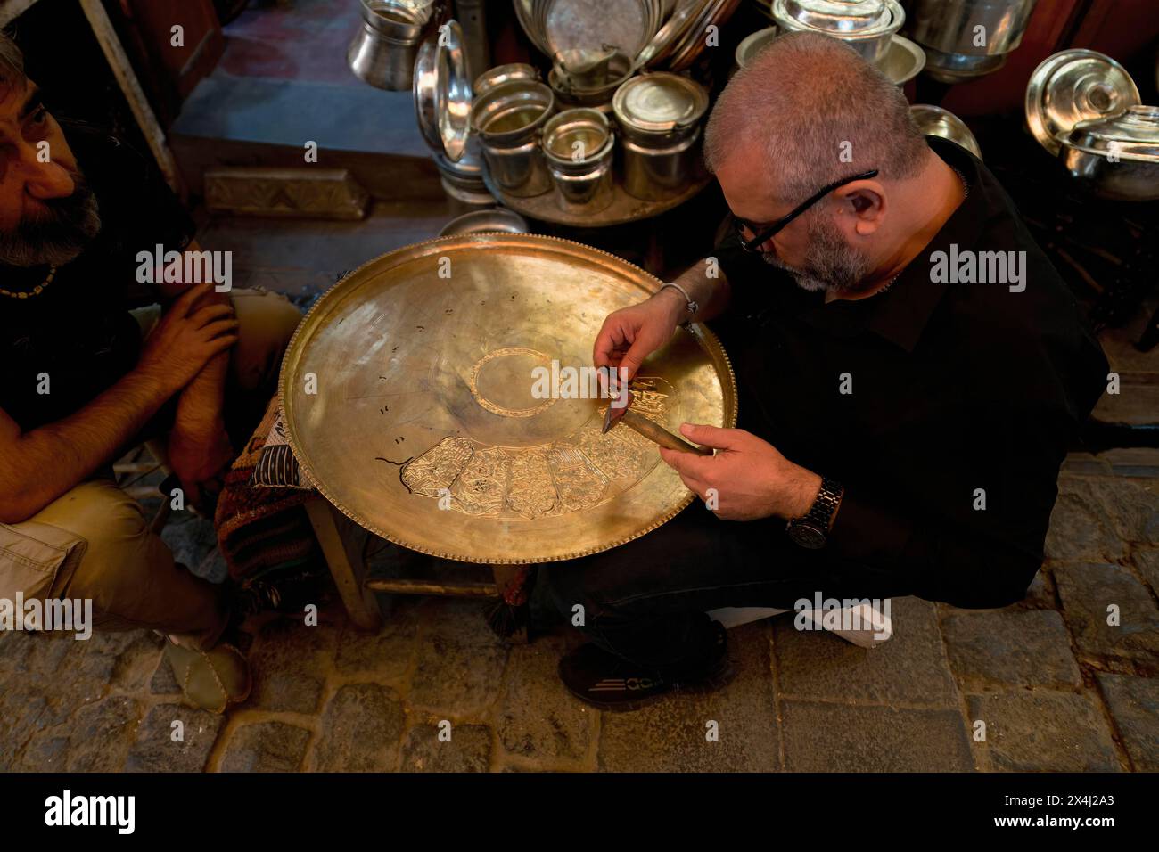Coppersmith at work engraving a copper plate, Gaziantep bazaar, Turkey ...