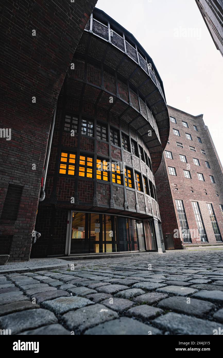 Historic brick building with characteristic arched windows and paved ...