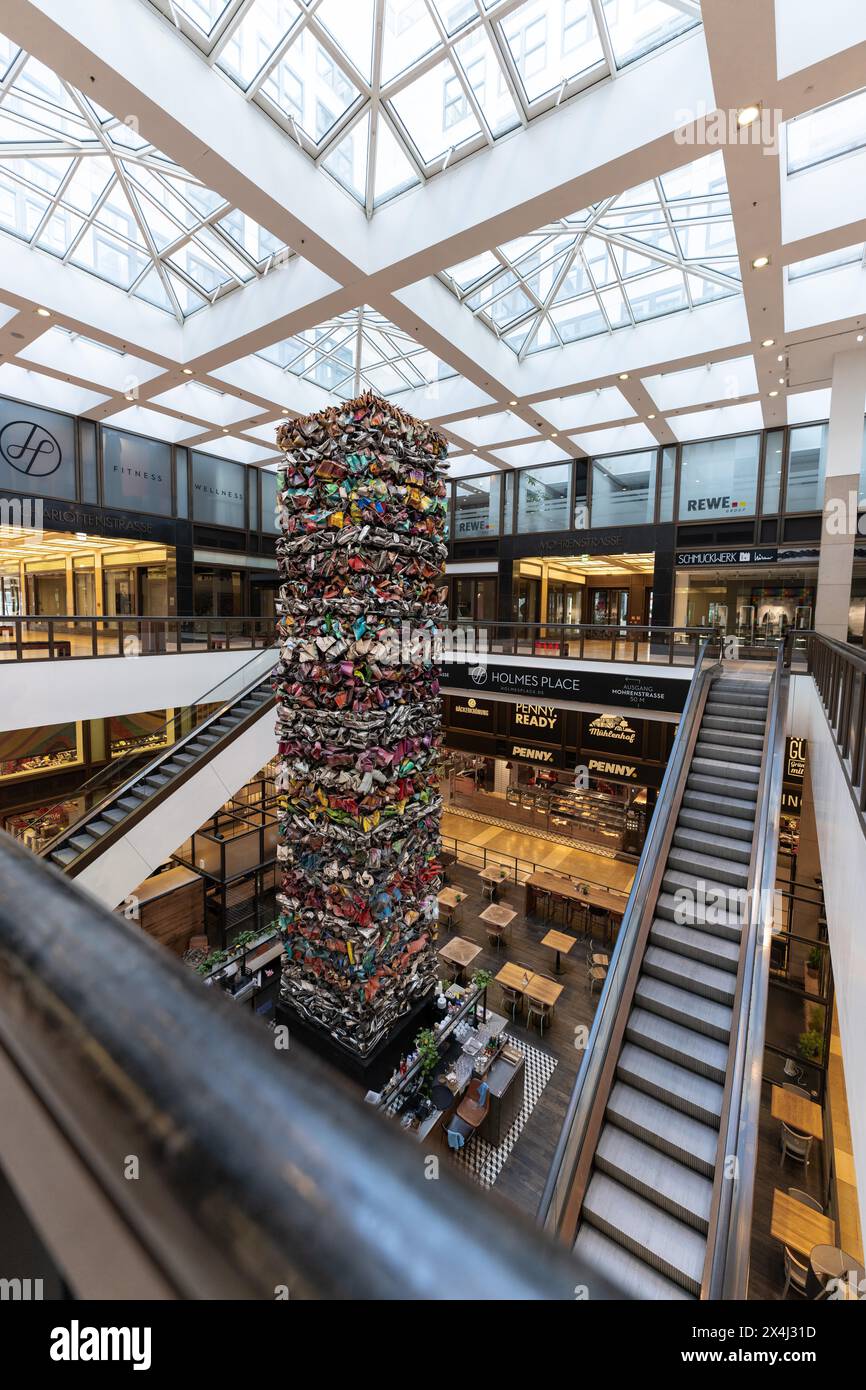 Multi-storey shopping centre with escalators and a central art ...
