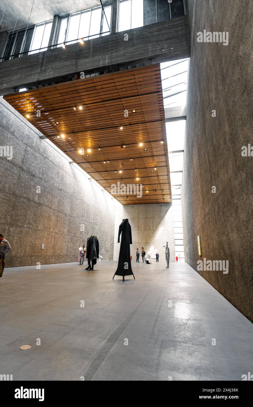 Wide museum hall with concrete walls, wooden ceiling and monumental ...