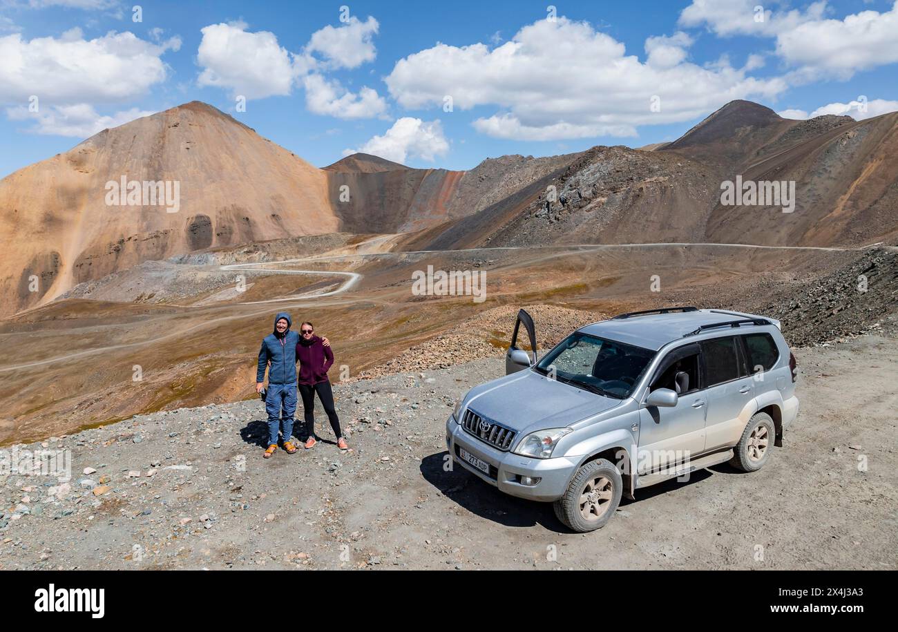 Two tourists with car at the mountain pass in Tien Shan, Chong Ashuu ...