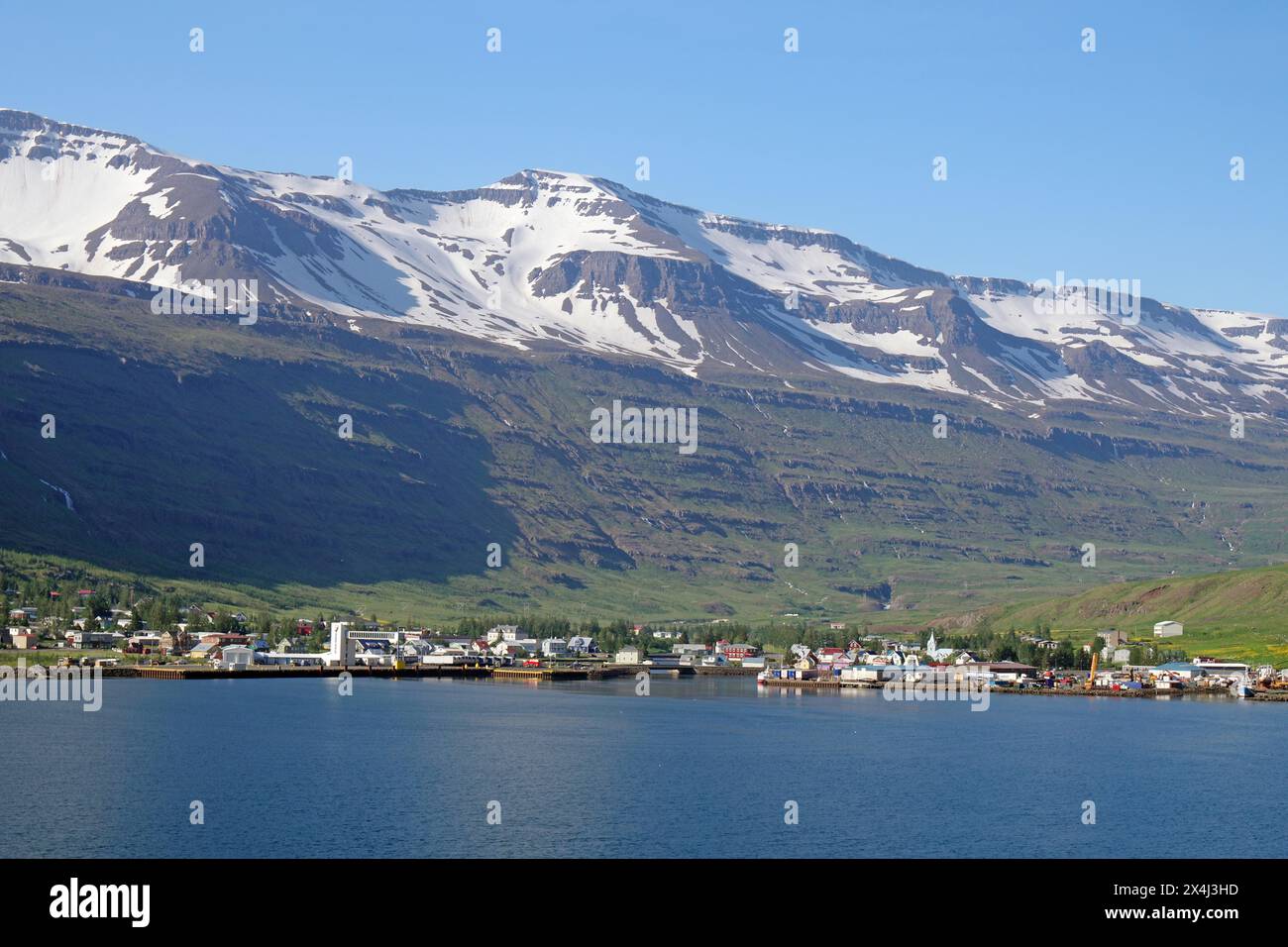 Small village under snow-covered, rugged mountains, ferry town ...