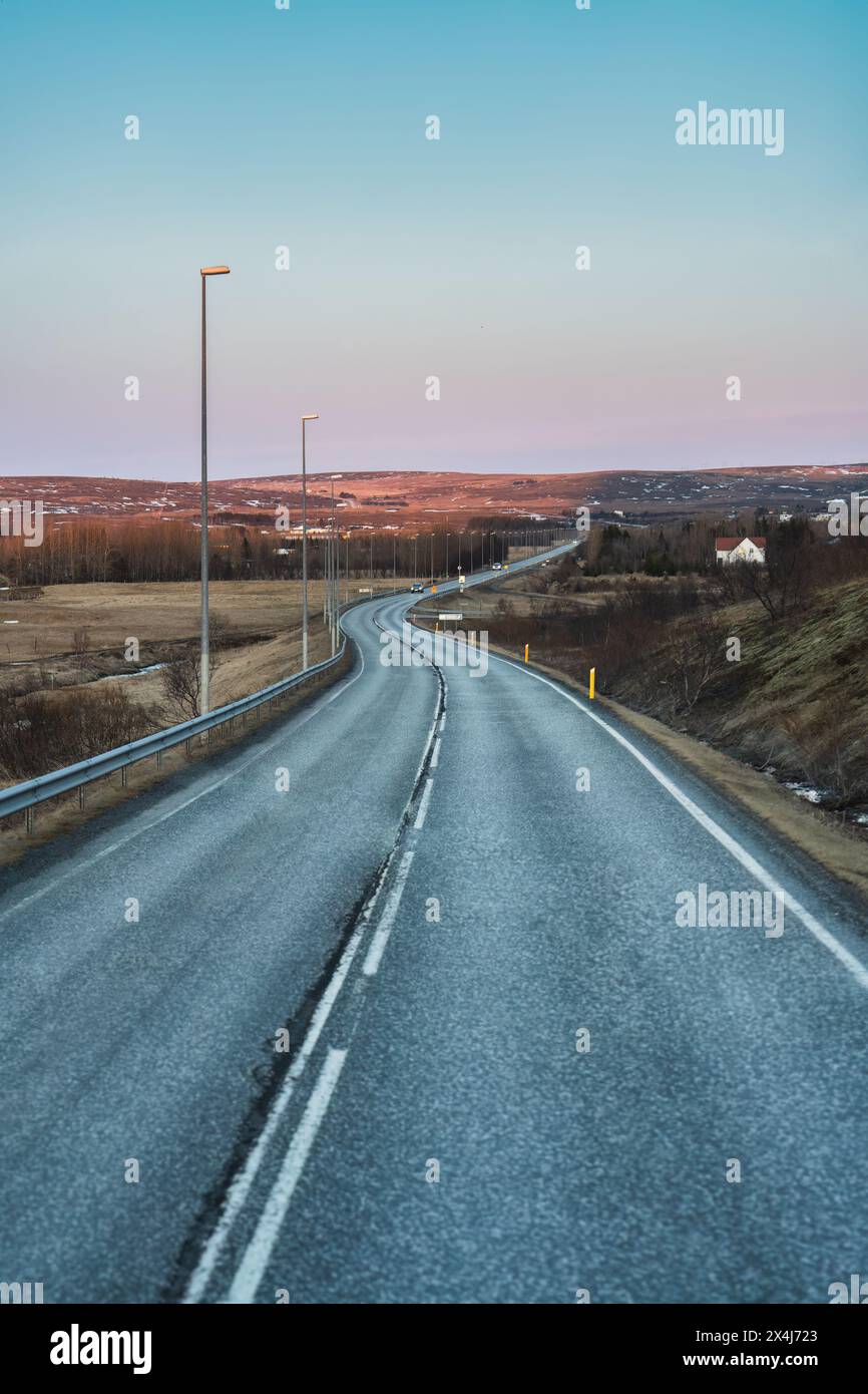 Curved asphalt highway road with electricity pylon among the volcanic ...