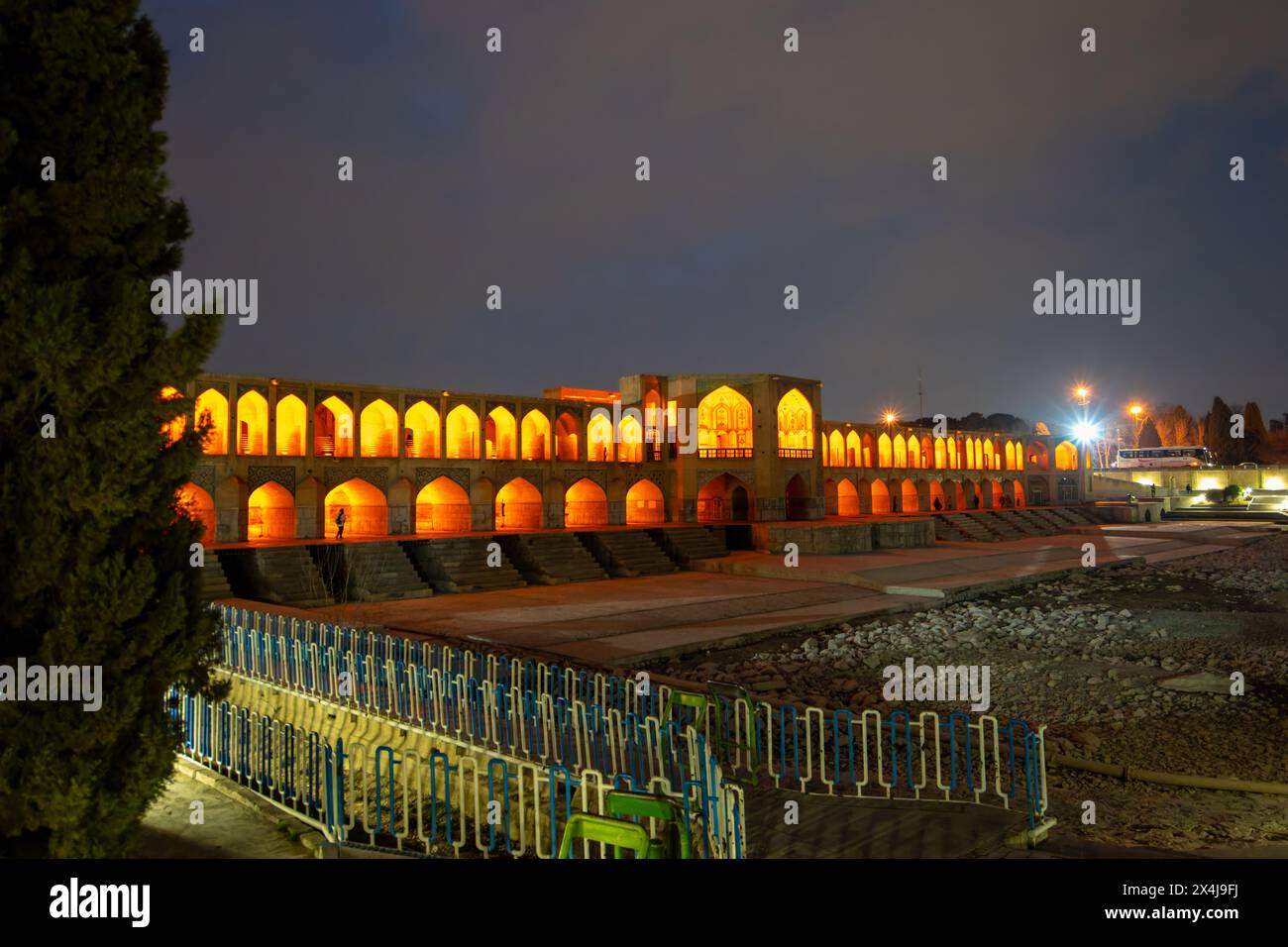 The historic Khaju Bridge glows with vibrant orange lights under the ...
