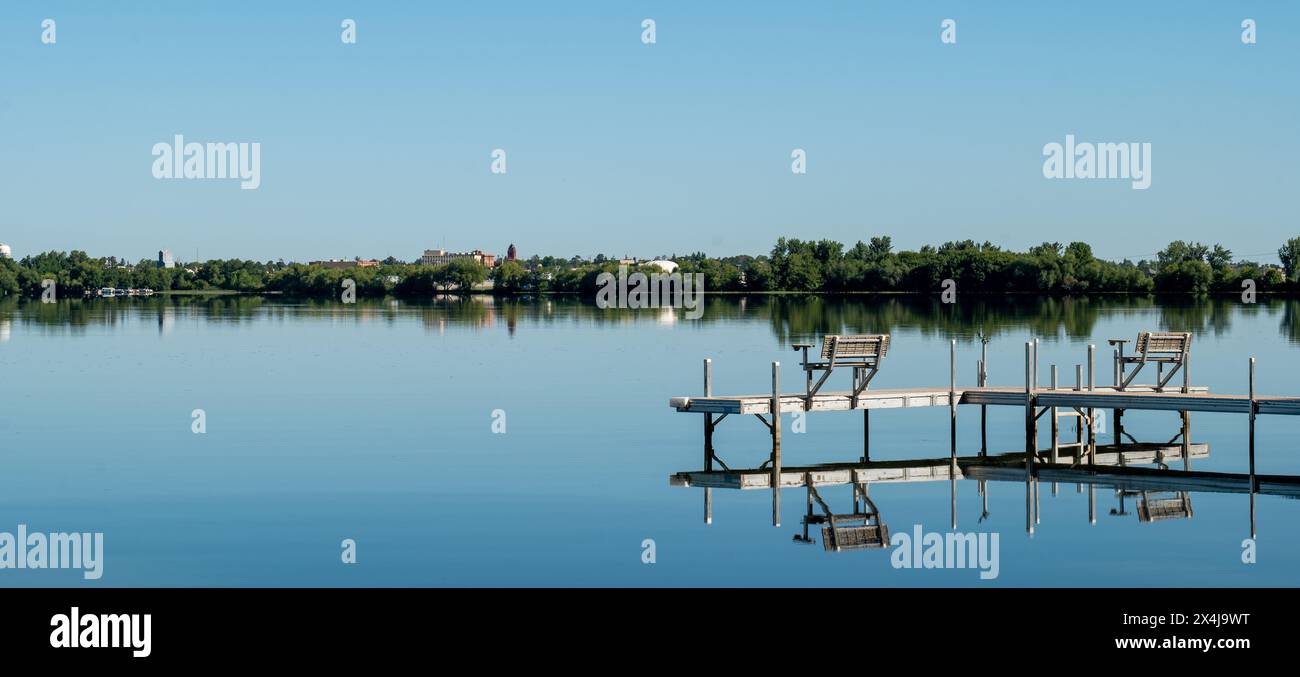 An inviting boat dock is reflected in the glassy water of Lake Irving ...
