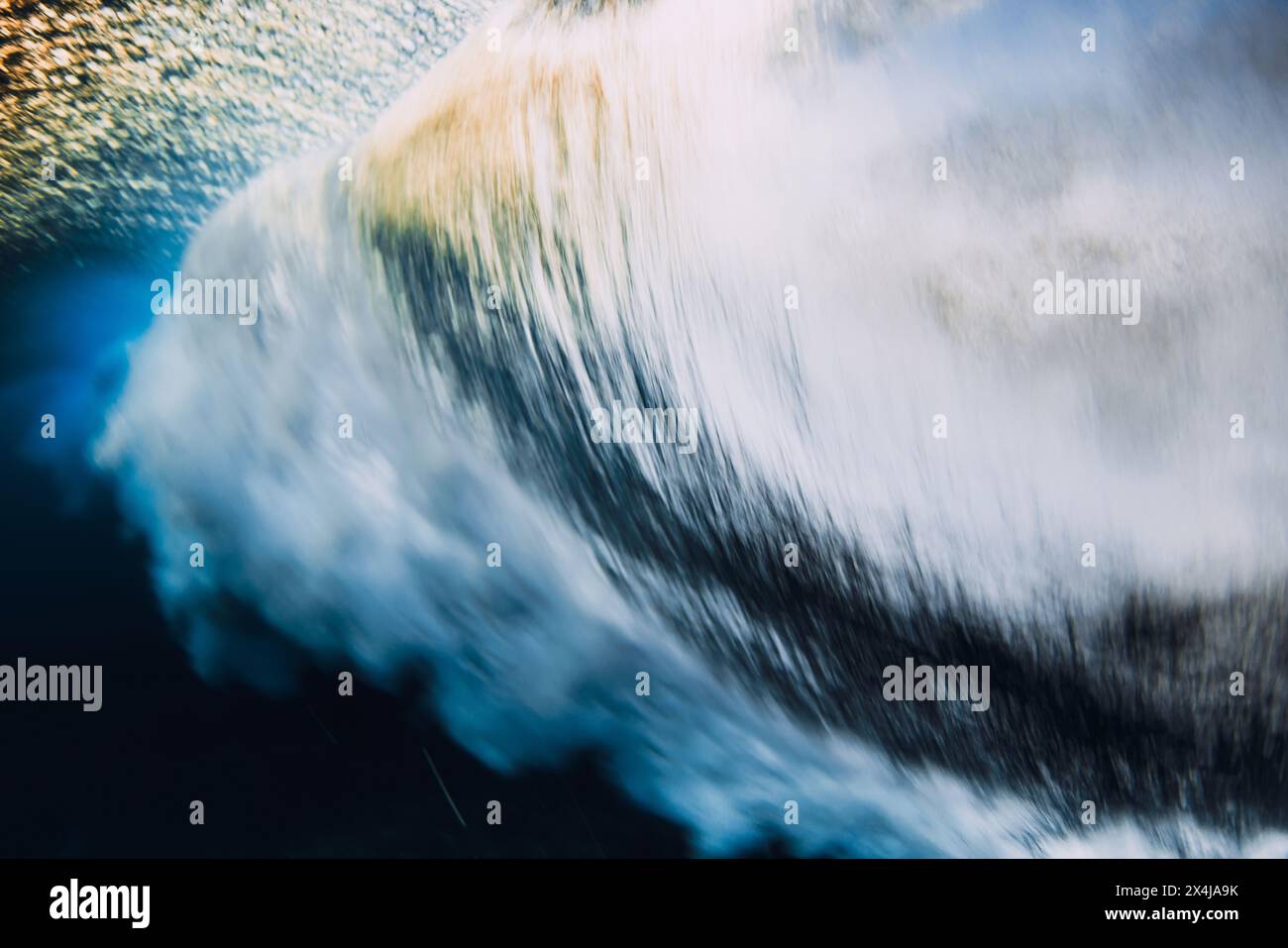Barrel wave crashing in ocean with sunset or sunrise light. Underwater ...