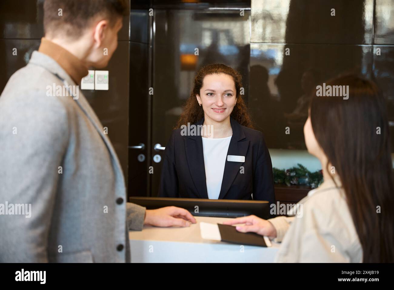 Cheerful woman welcoming guests hi-res stock photography and images - Alamy