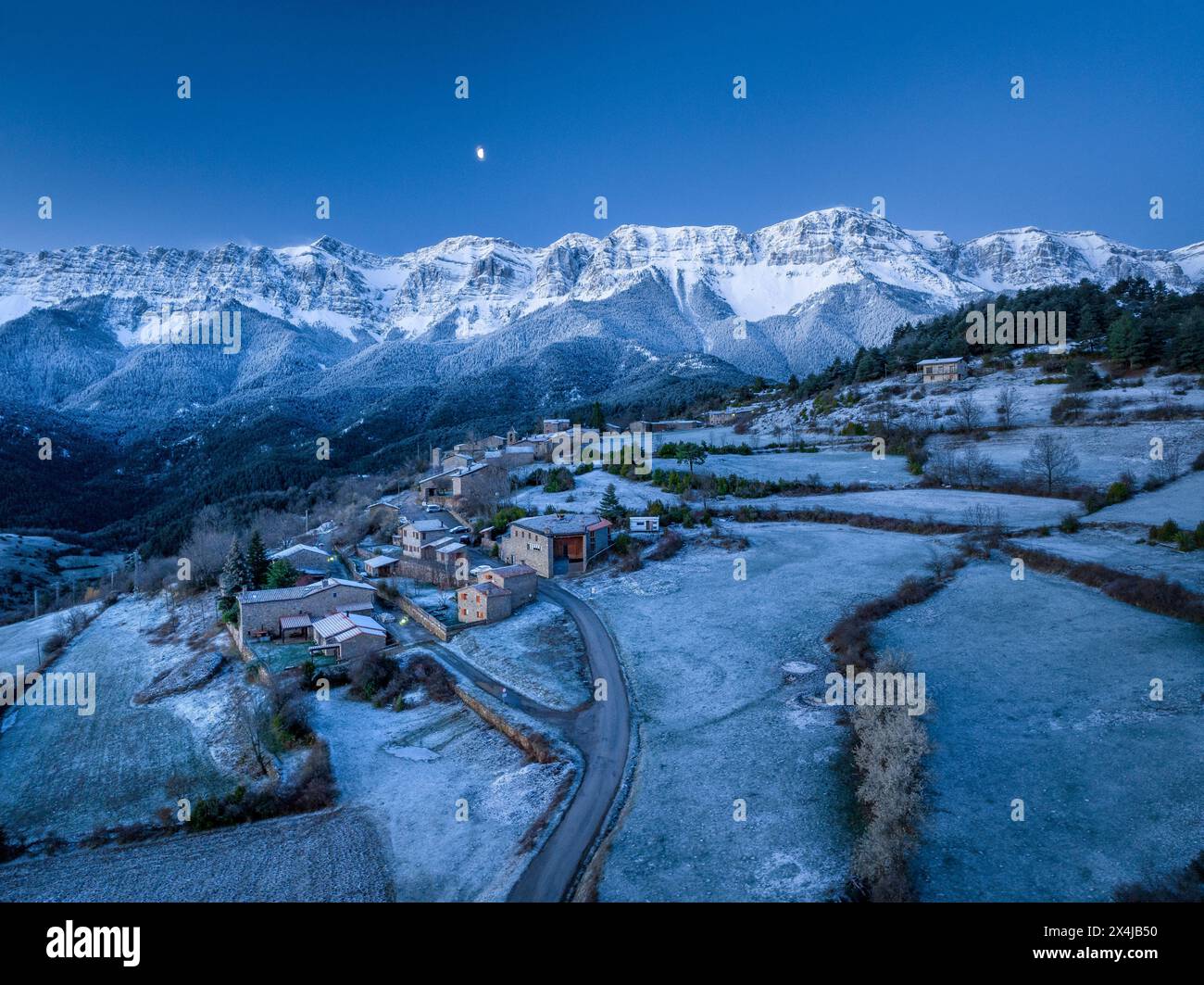 Aerial view of the village of Estana and the snow-capped Serra del Cadí ...