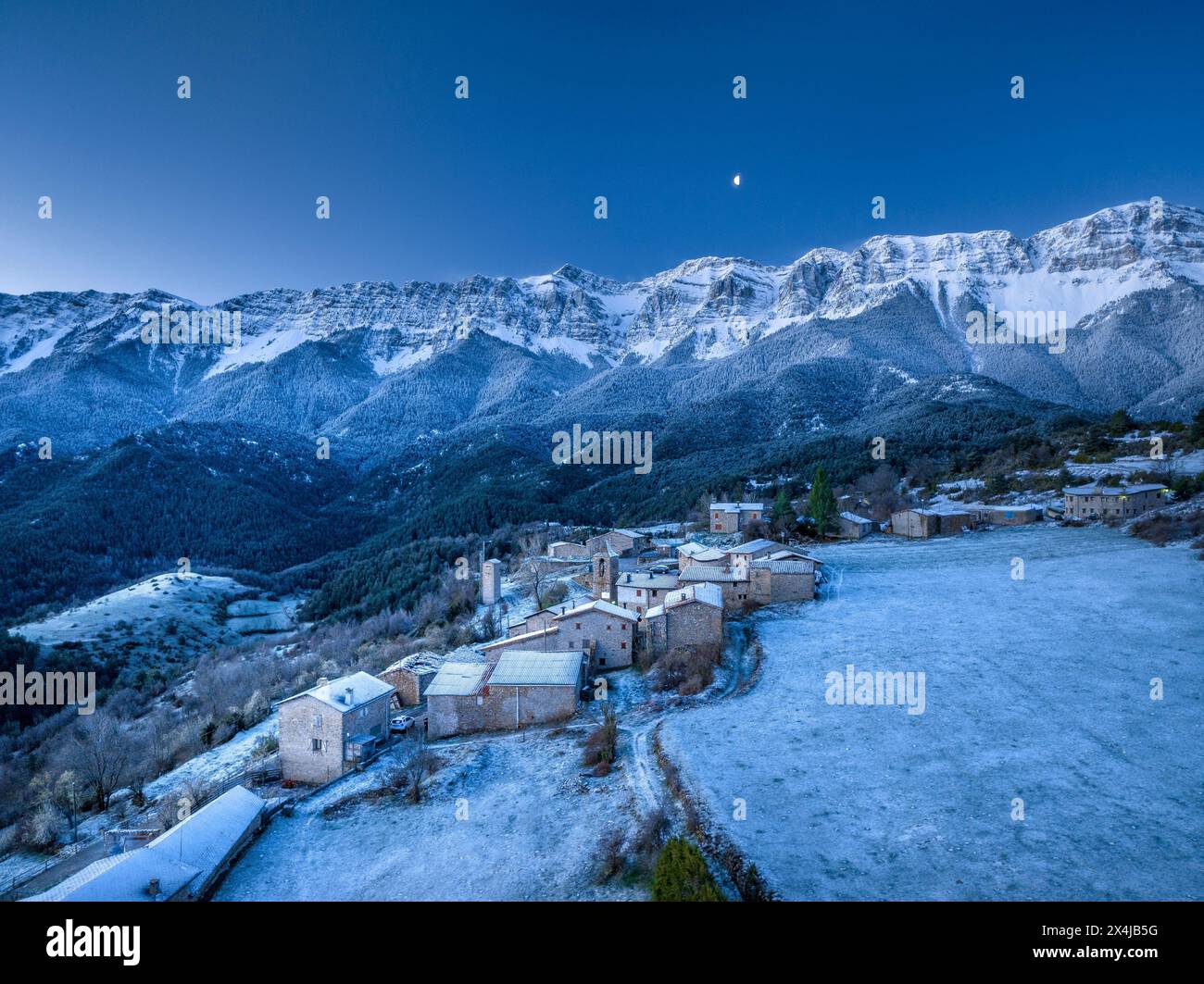 Aerial view of the village of Estana and the snow-capped Serra del Cadí ...