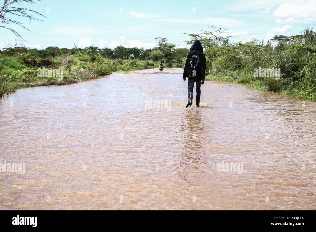 A man wades in a flooded road in Rongai, Nakuru County, following ...