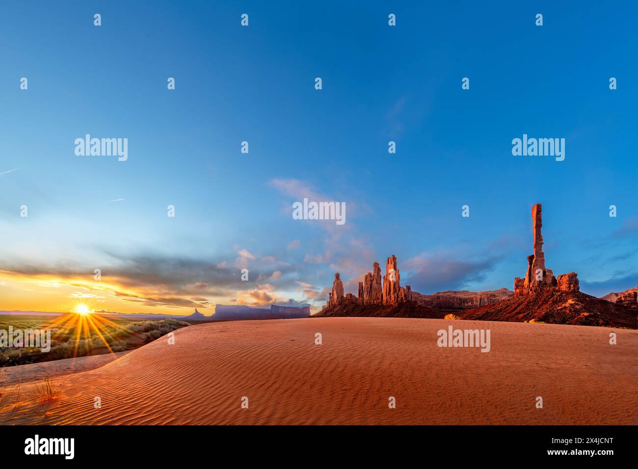 Mountainside lit up by a rising sun casts an orange color against the ...