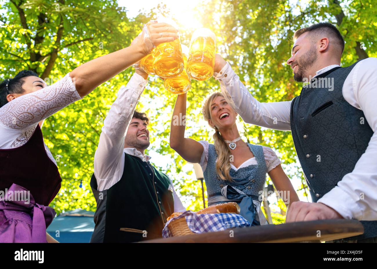 Group of happy Bavarian friends drinking and toasting beer at beer ...