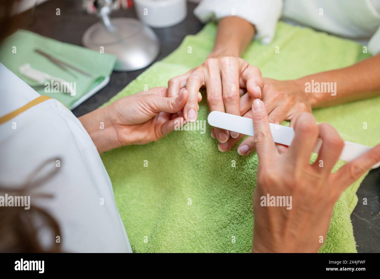 Manicurist buffing nails during a manicure session in a beauty salon ...