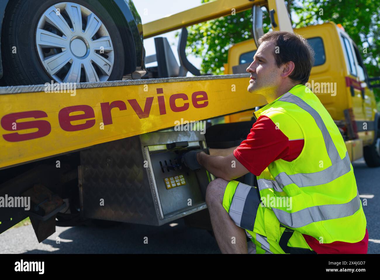 Roadside service professional worker operating machinery lift with a ...