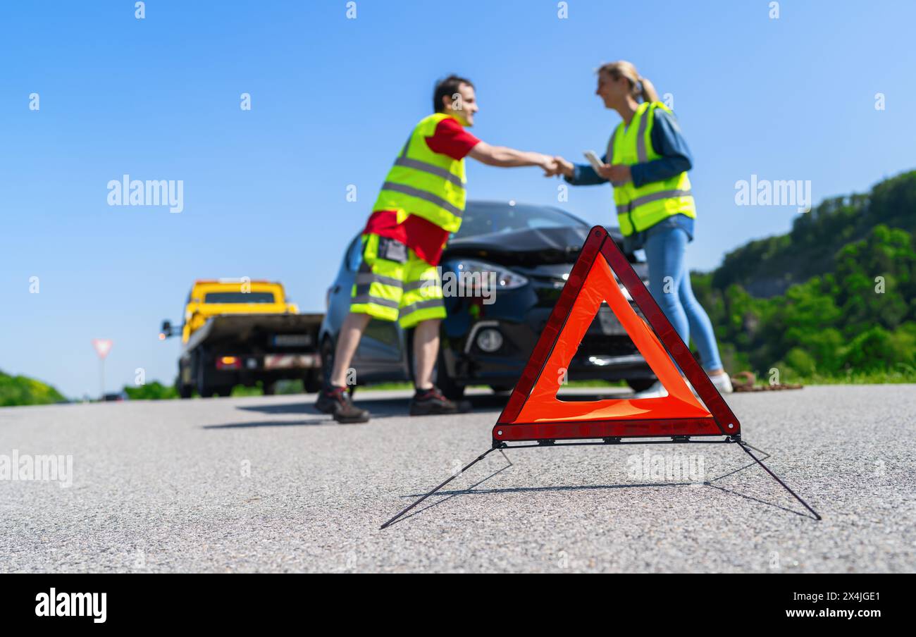 Roadside assistance worker and customer in high visibility vests ...