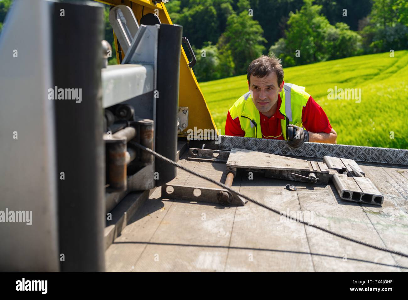 Tow truck driver uses a winch on a tow truck to tow a car Stock Photo ...