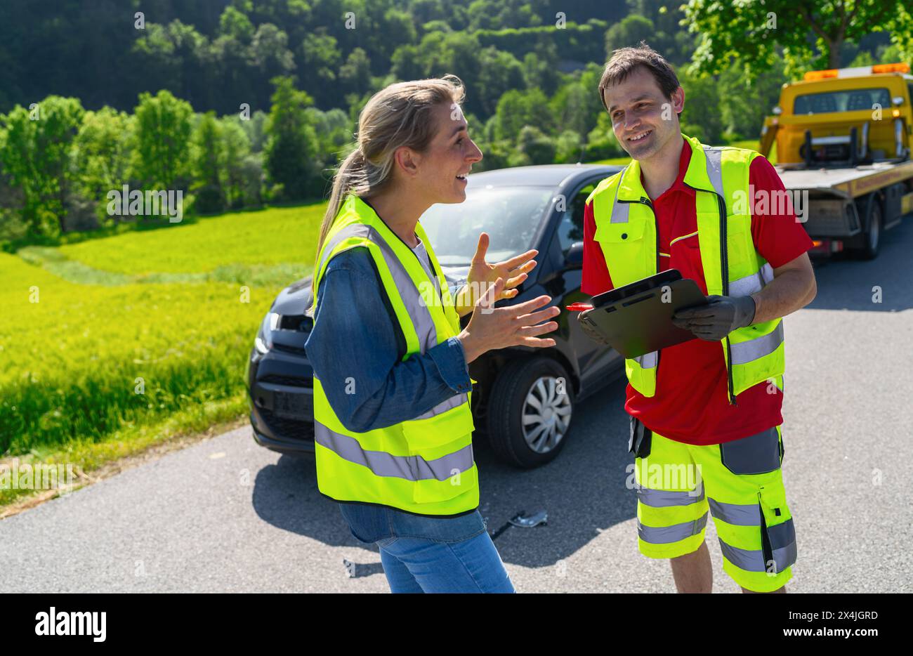 Roadside assistance worker with clipboard talking discusses an accident ...