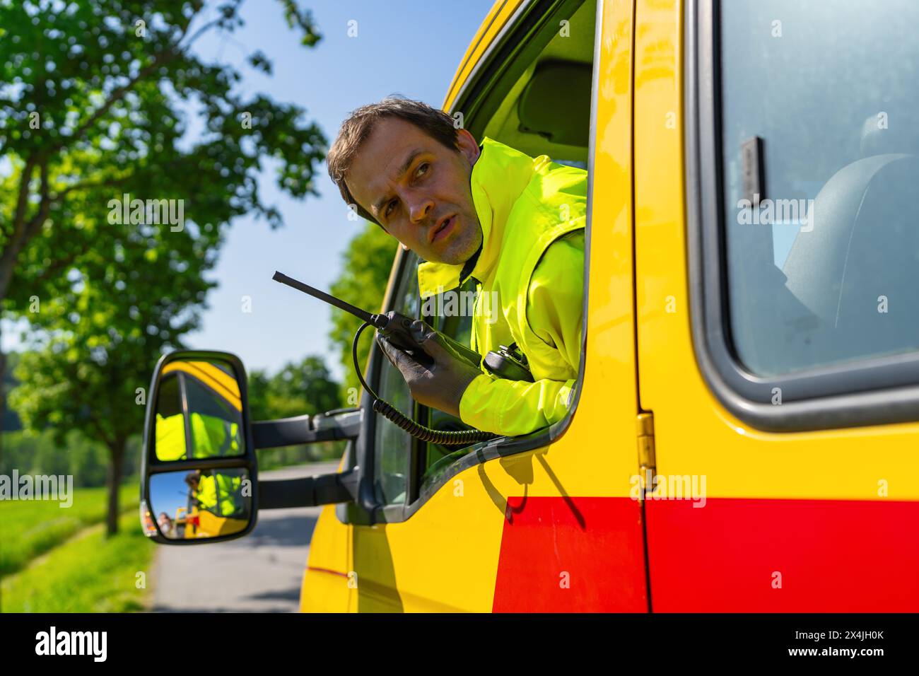 Tow truck operator using walkie-talkie to coordinate the journey for ...