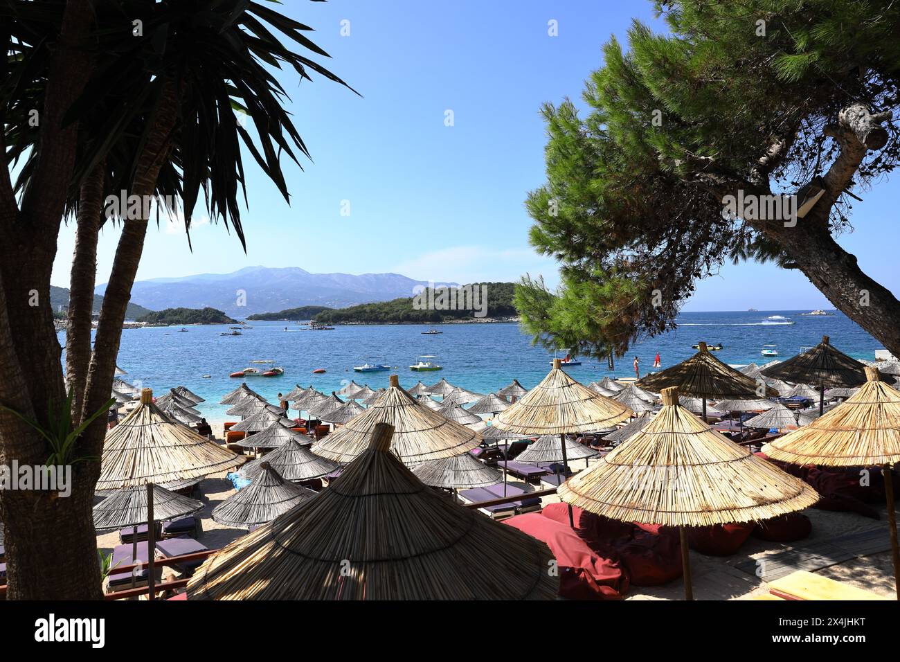 Ksamil, Albania, beach with sunbeds and straw umbrellas on the Albanian ...