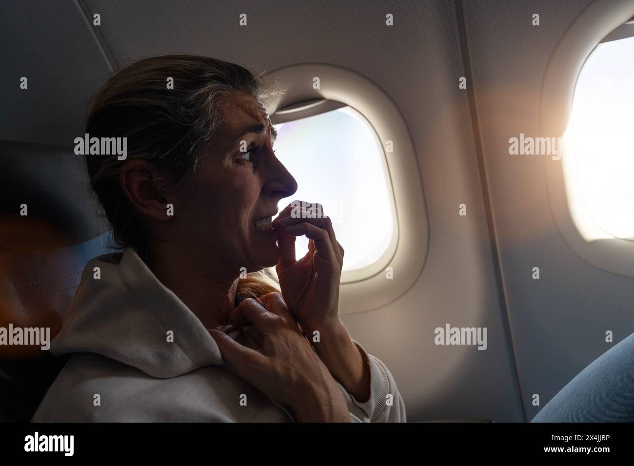 Woman with aerophobia in airplane cabin is afraid to fly on an airplane ...