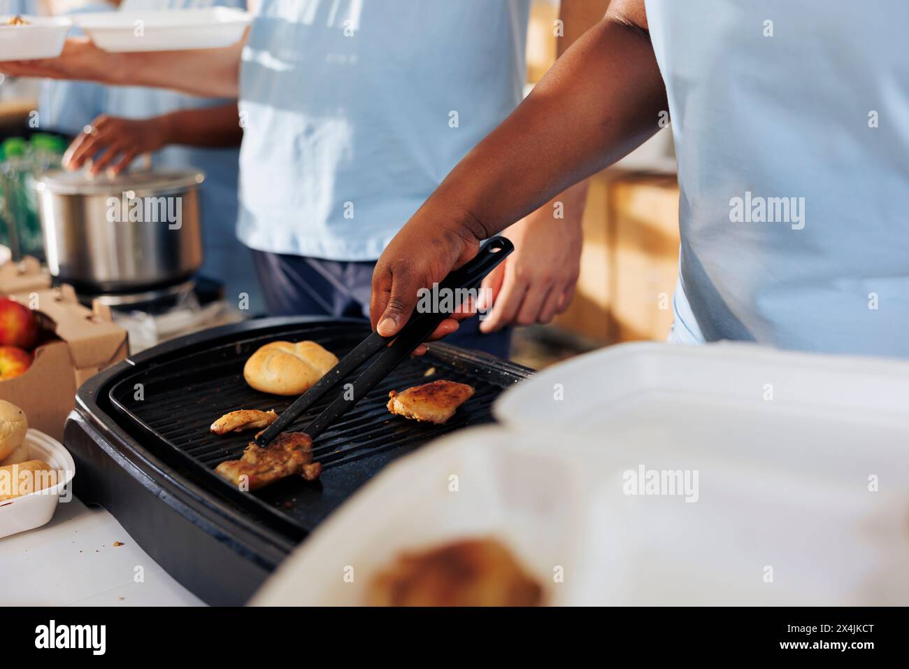 Close-up shot of black woman and caucasian man cooking a free meal for ...