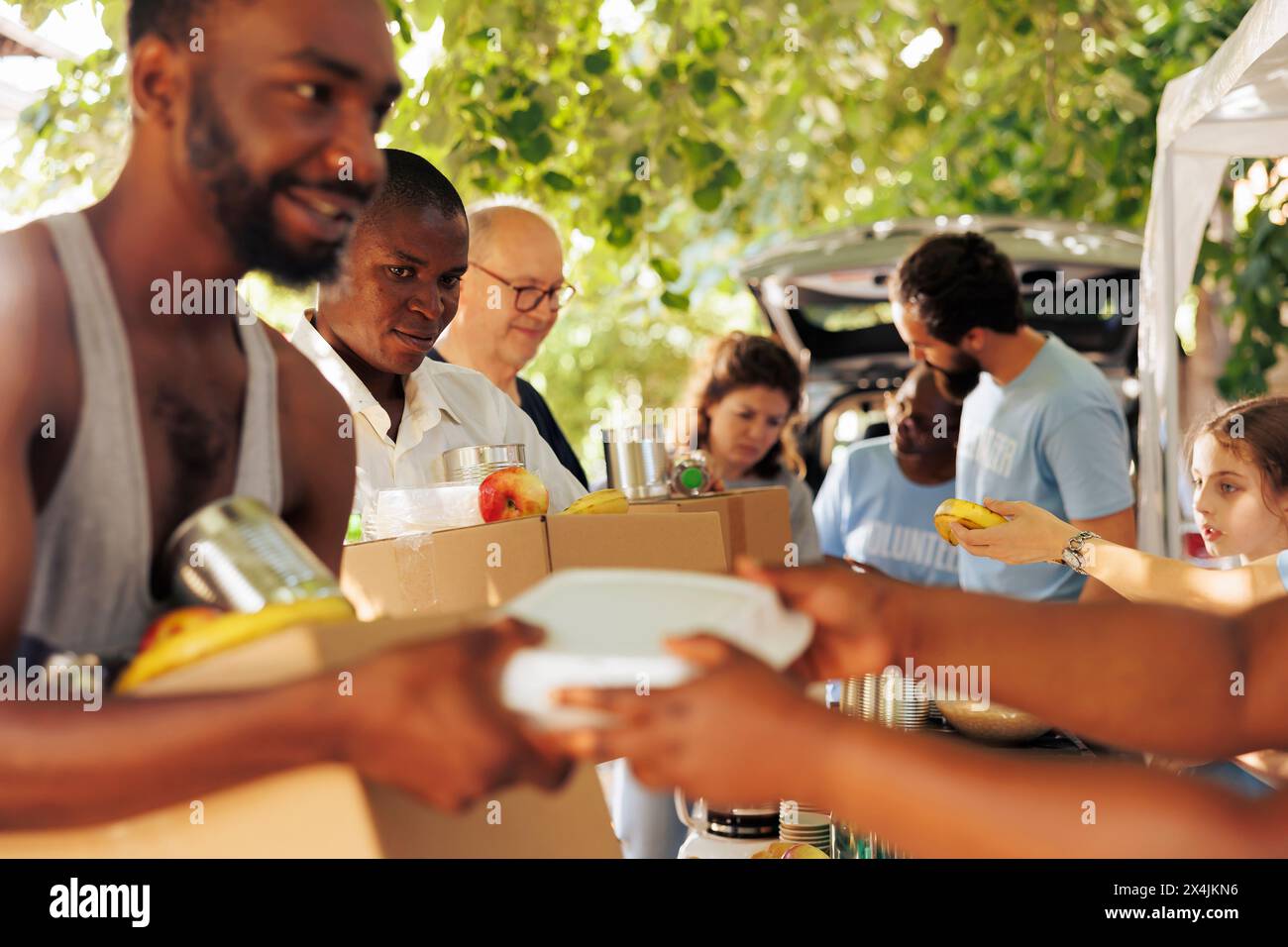 Multiethnic group of volunteers providing humanitarian aid to homeless people. They distribute ...