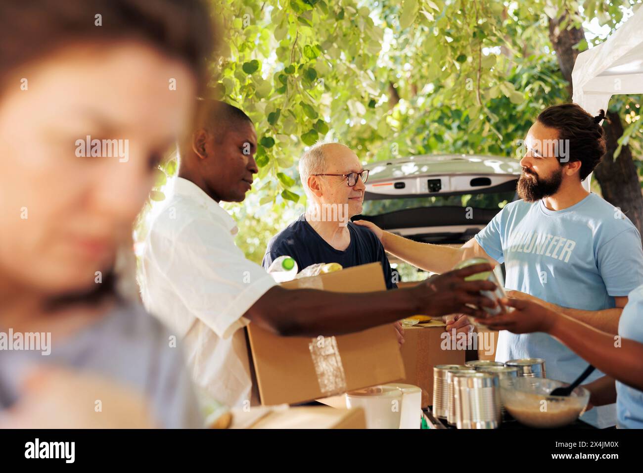 Compassionate group of volunteers providing food to the poor, sharing ...