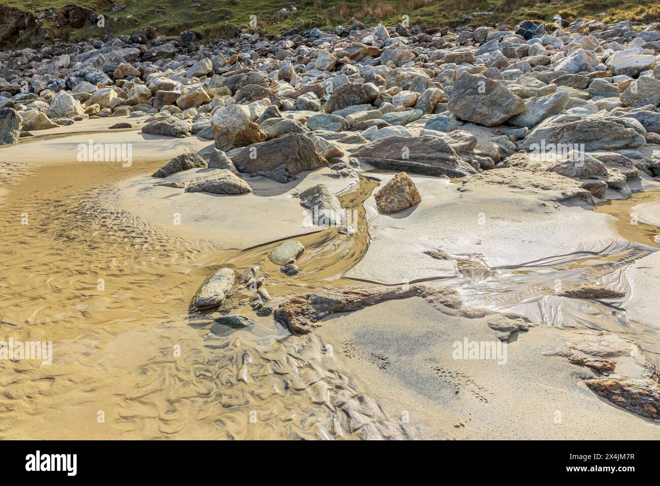 Water flowing down a hillside through some rocks creating a river on ...