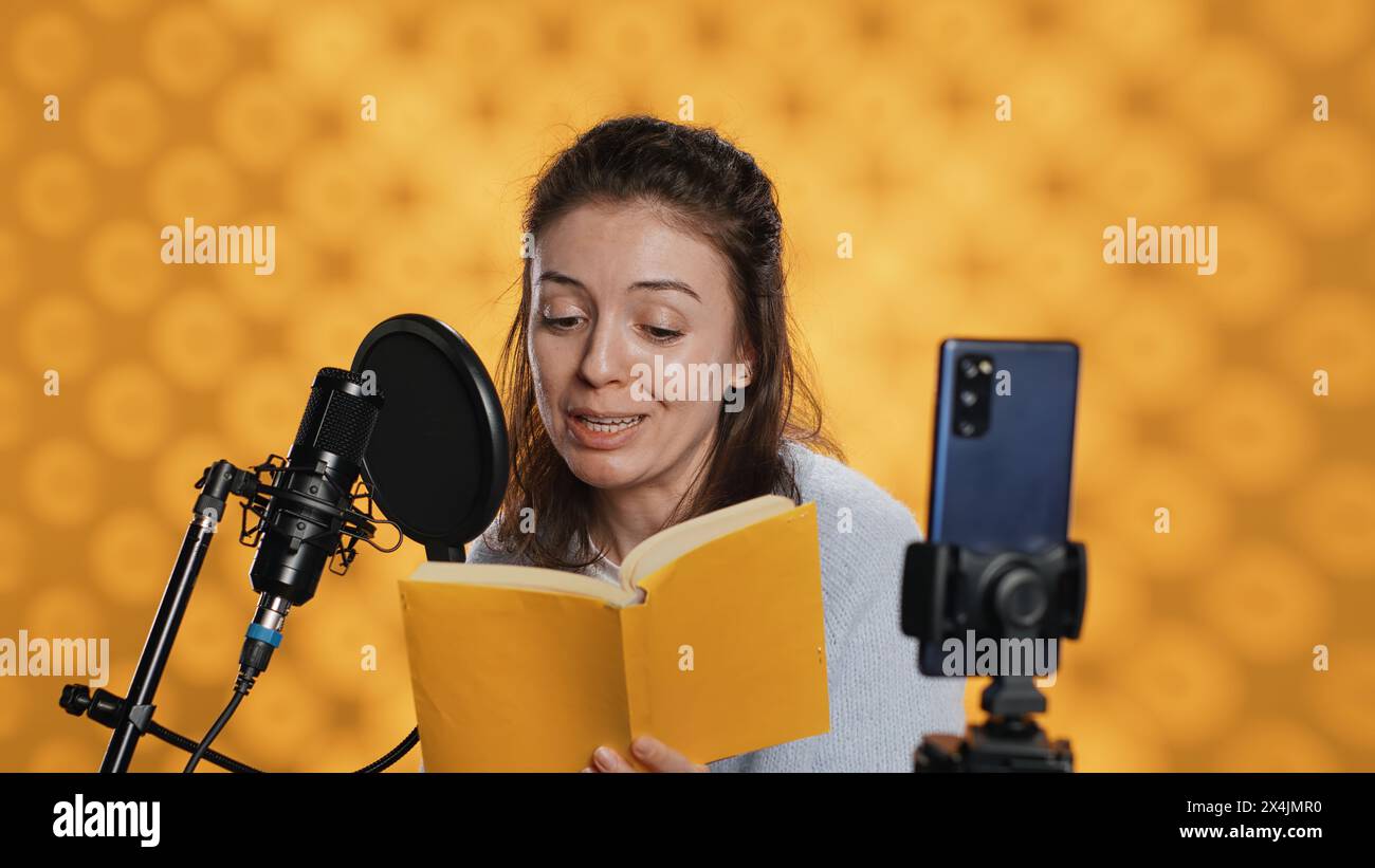 Media star filming vlog at work, reading book to record audiobook ...