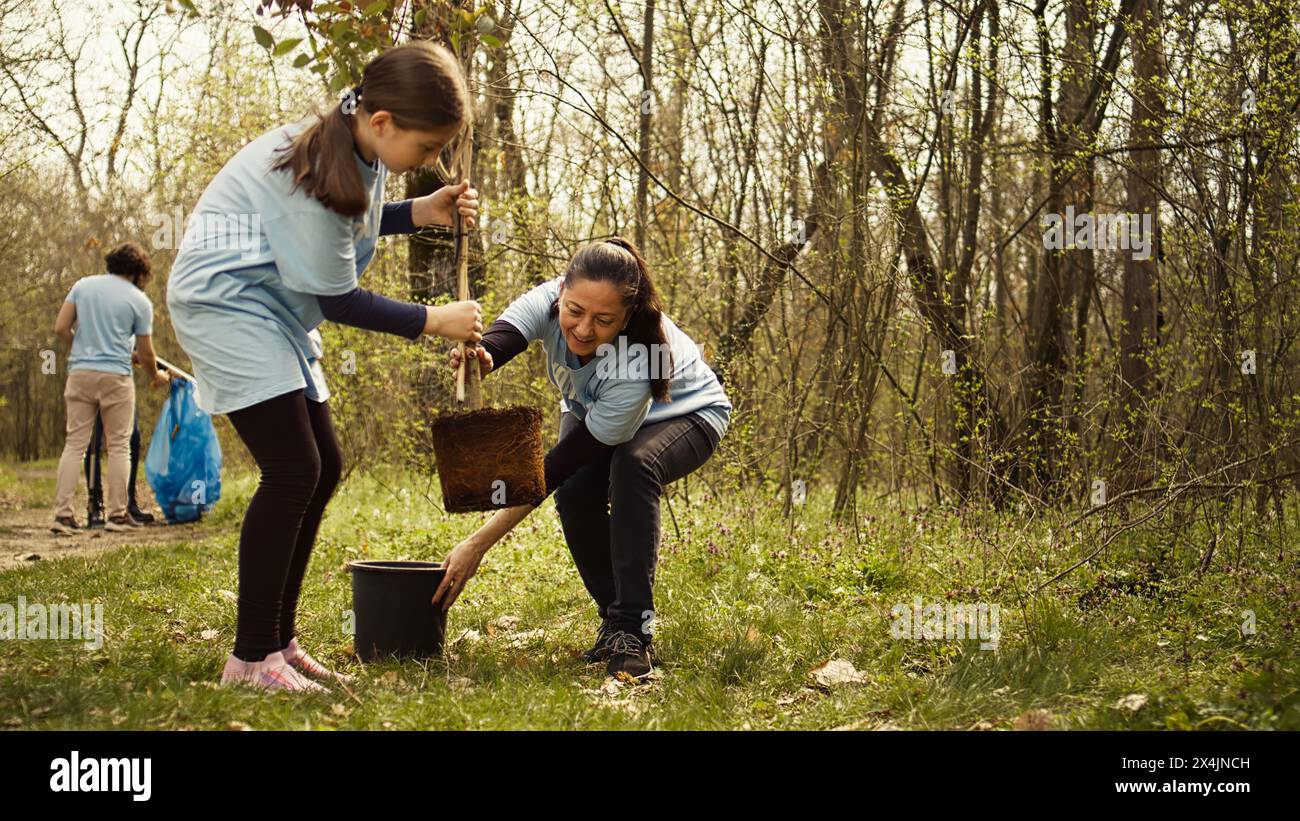 Mother and daughter team up to plant new trees in the woods, protecting ...