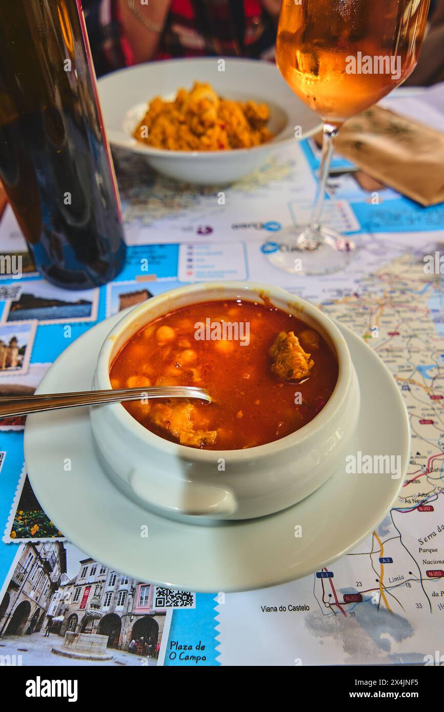 A plate of appetizing soup in a travel setting, with a placemat that ...