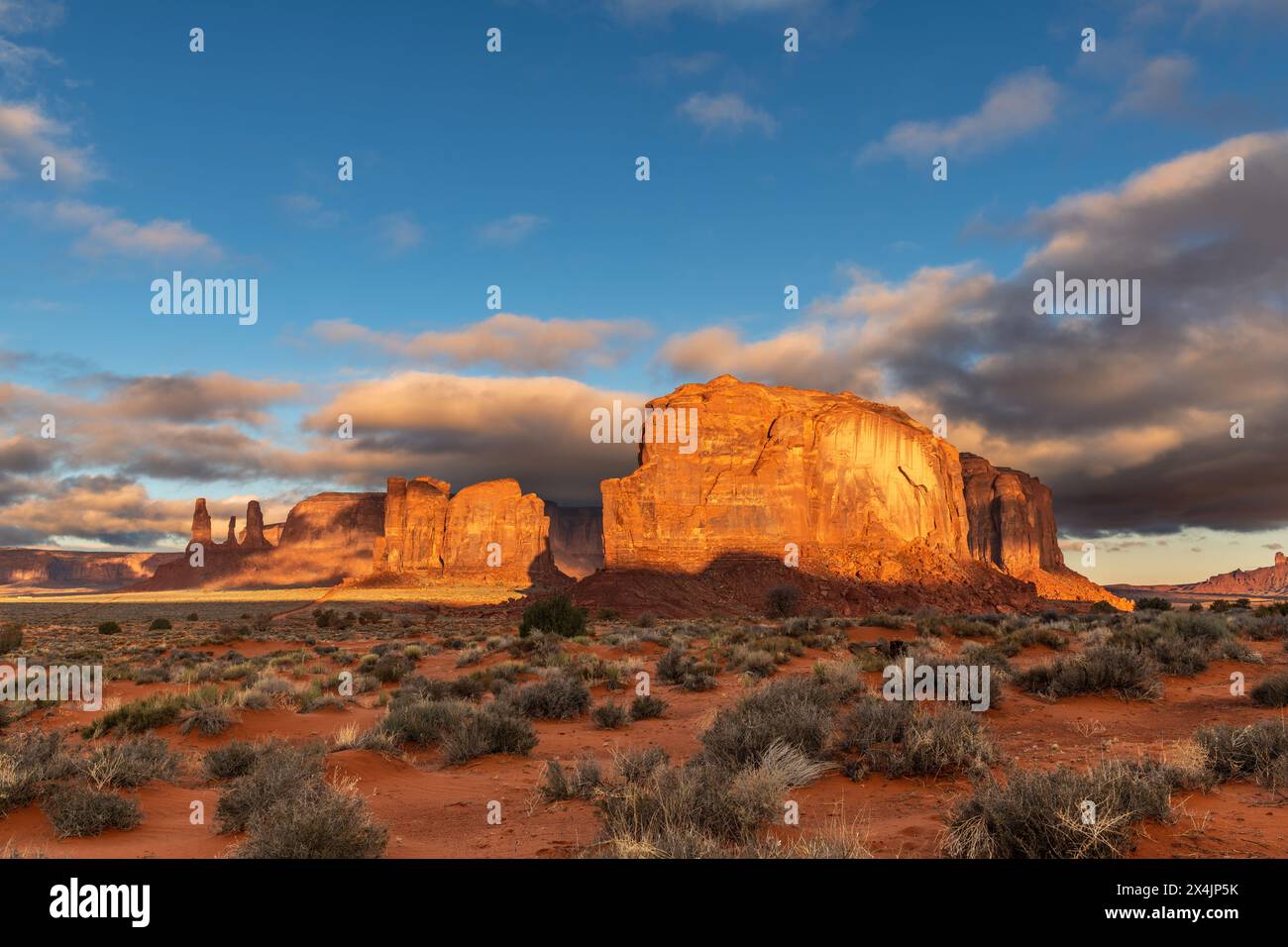 Mountainside lit up by a rising sun casts an orange color against the ...